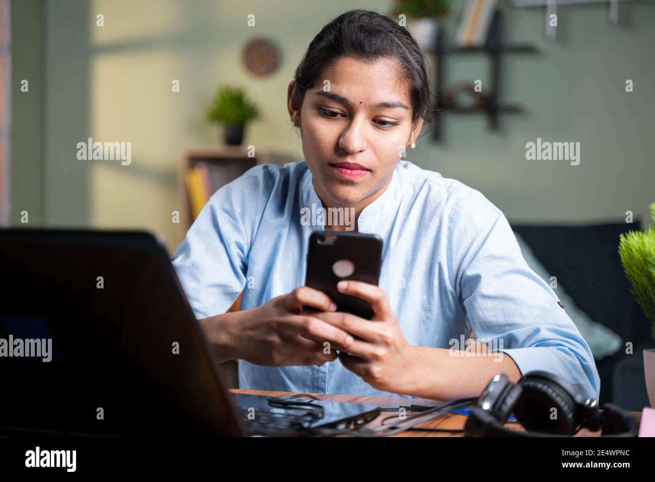 Young Indian Business woman using mobile during working in front of ...