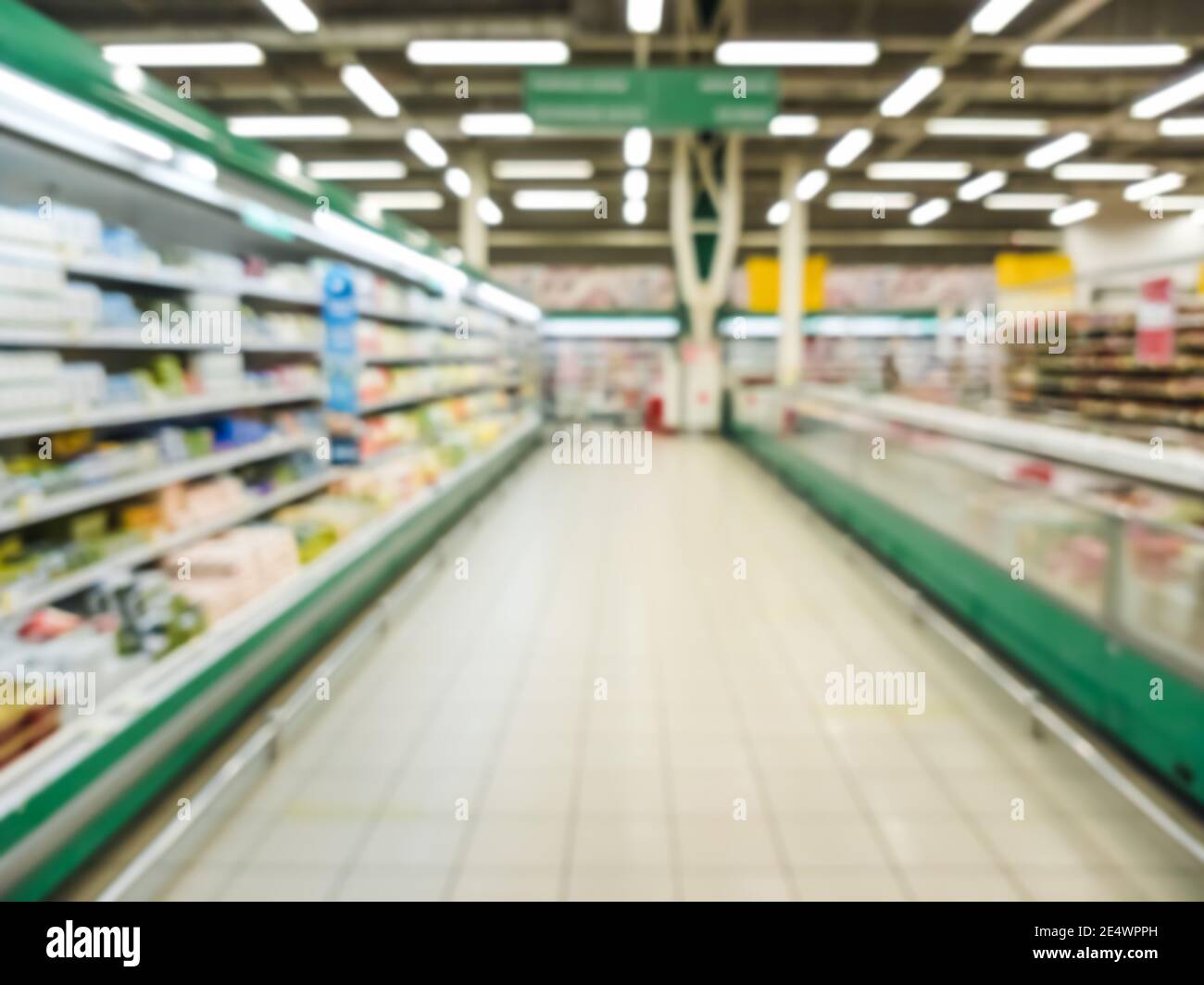 Blurred supermarket aisle with colorful refregirator shelves of ...