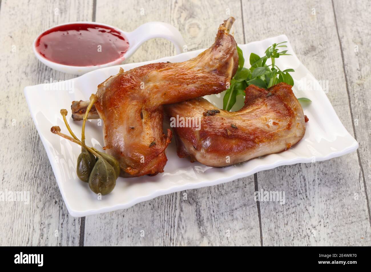 Roasted rabbit legs with cowberry sauce Stock Photo - Alamy