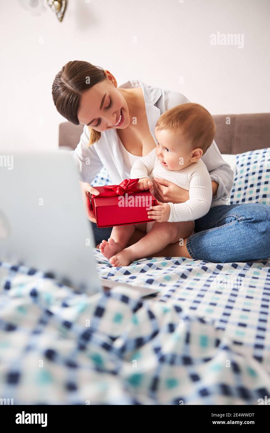Cheerful female person giving present to her child Stock Photo - Alamy