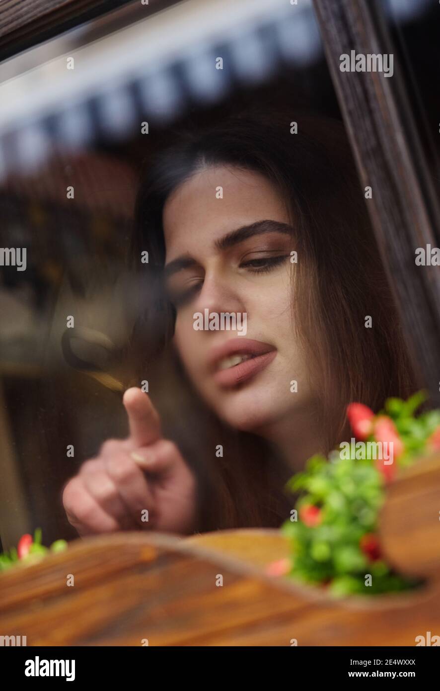 Young woman drawing a heart on the window Stock Photo - Alamy