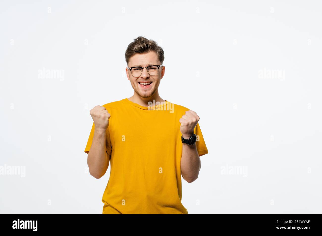 Casual man winning and celebrating handsome young man with hands lifted ...