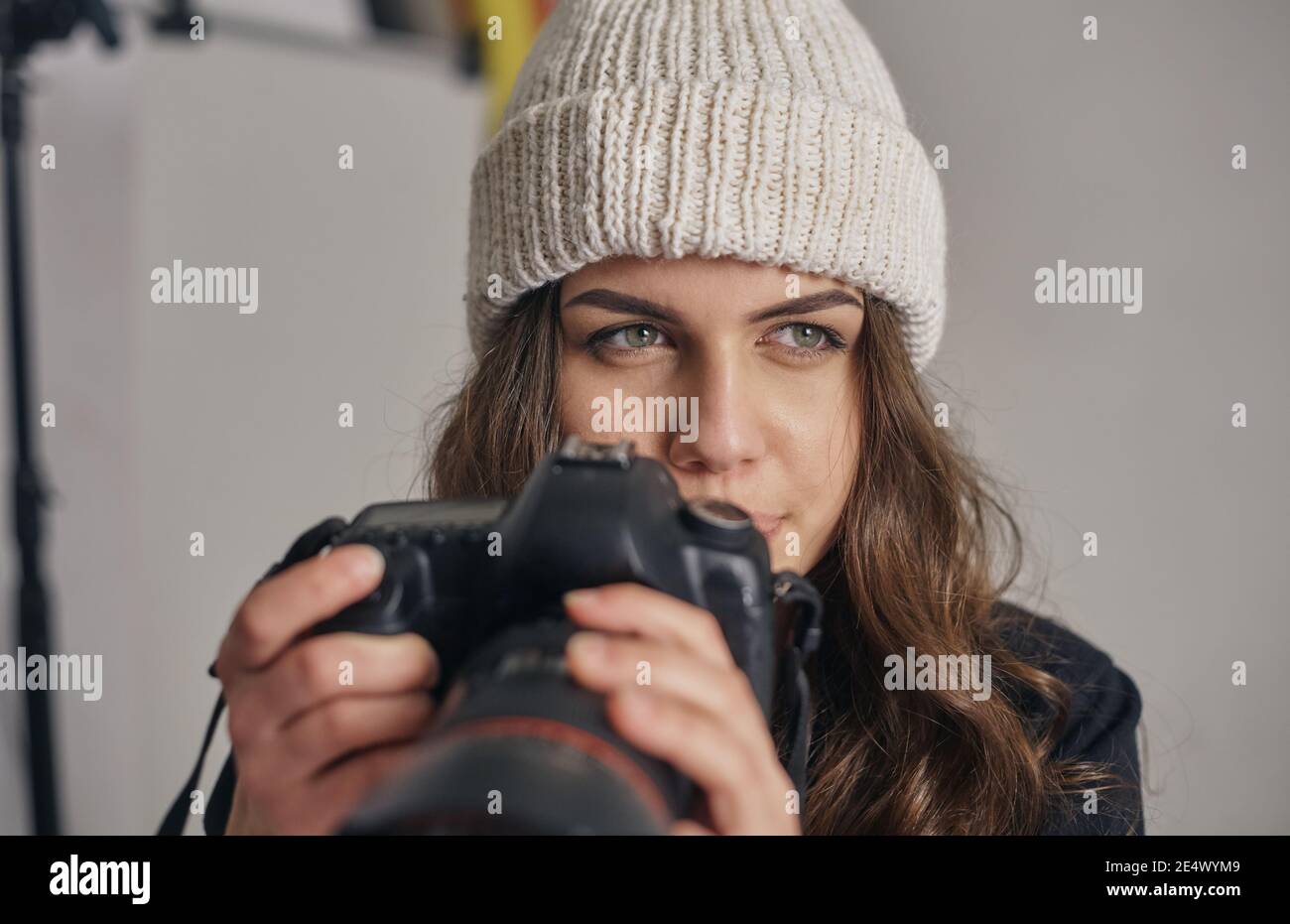 Close up photo of woman in hat on studio background taking a photo with ...