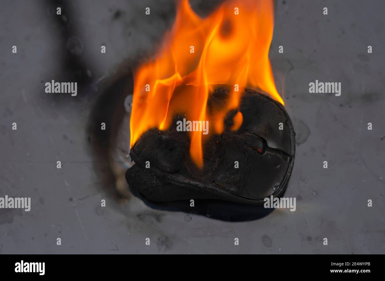 Household electrical appliance fire concept. Wireless computer mouse is ...