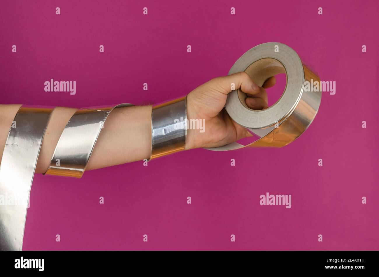 Hand wrapped with aluminum duct tape for padding. Man's hand with roll ...