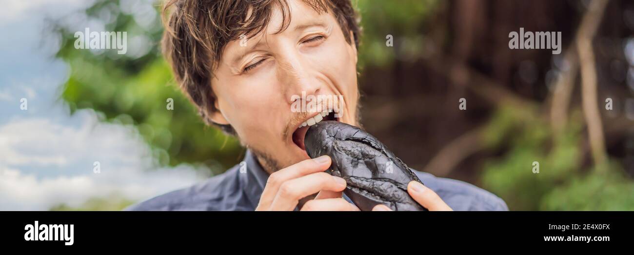 Man eating Vietnamese Pork Banh Mi Sandwich in a black baguette BANNER ...