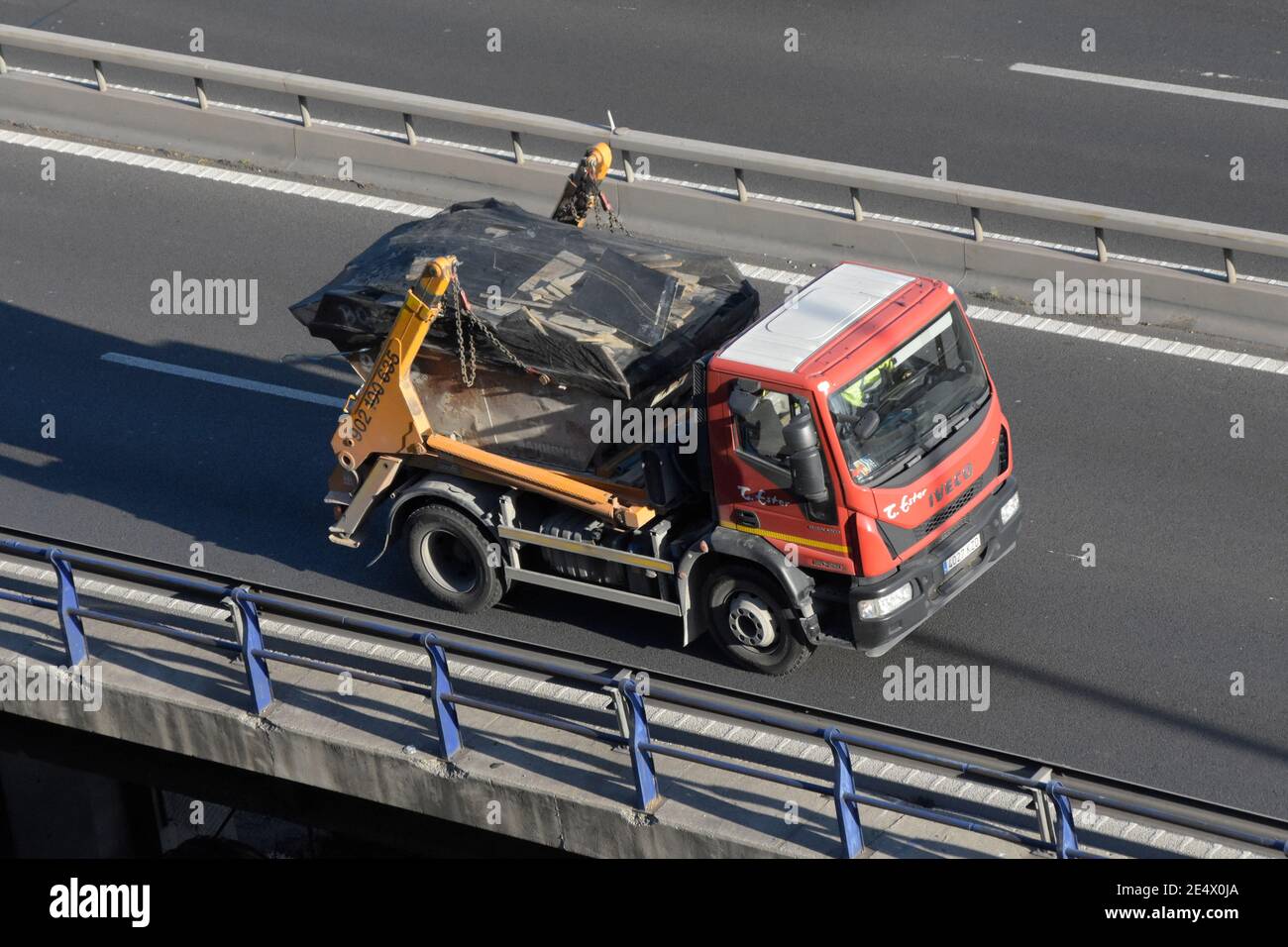 Red Iveco truck carrying container full of rubble Stock Photo - Alamy