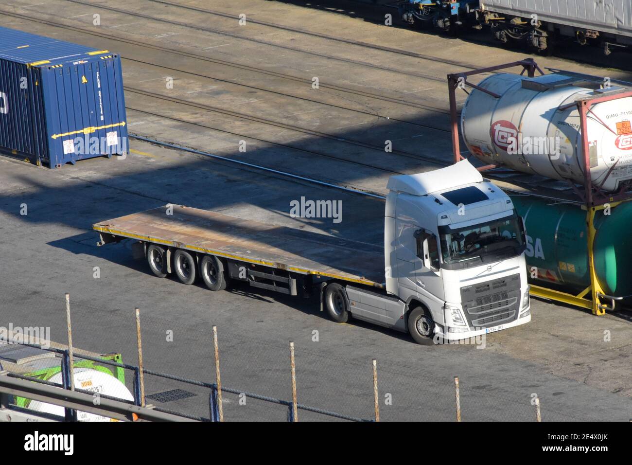 White Volvo truck without container in a port, waiting to load the ...