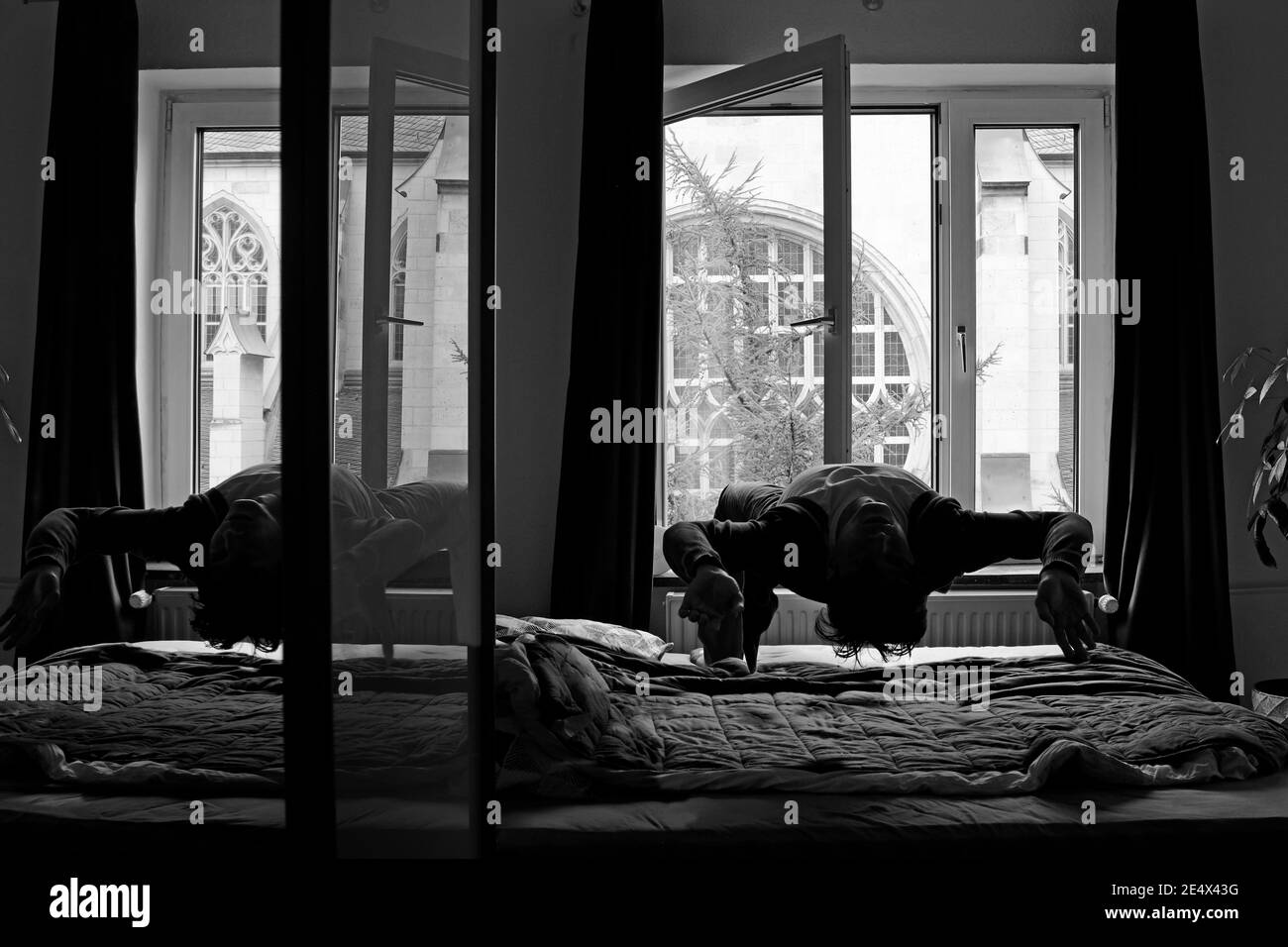 Scary black and white photo with a man seemingly levitating over a bed ...