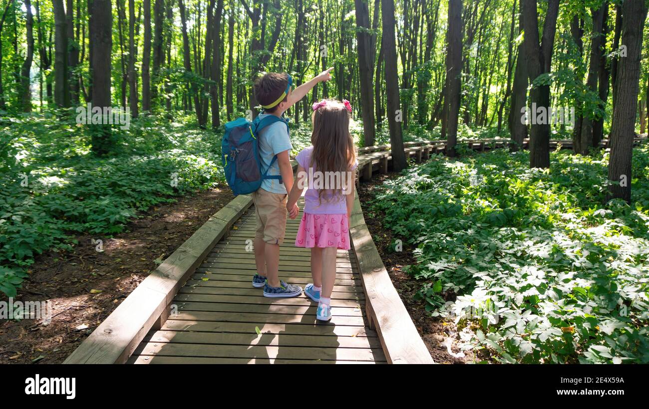 A boy and a girl holding hands explore the tourist hiking route ...