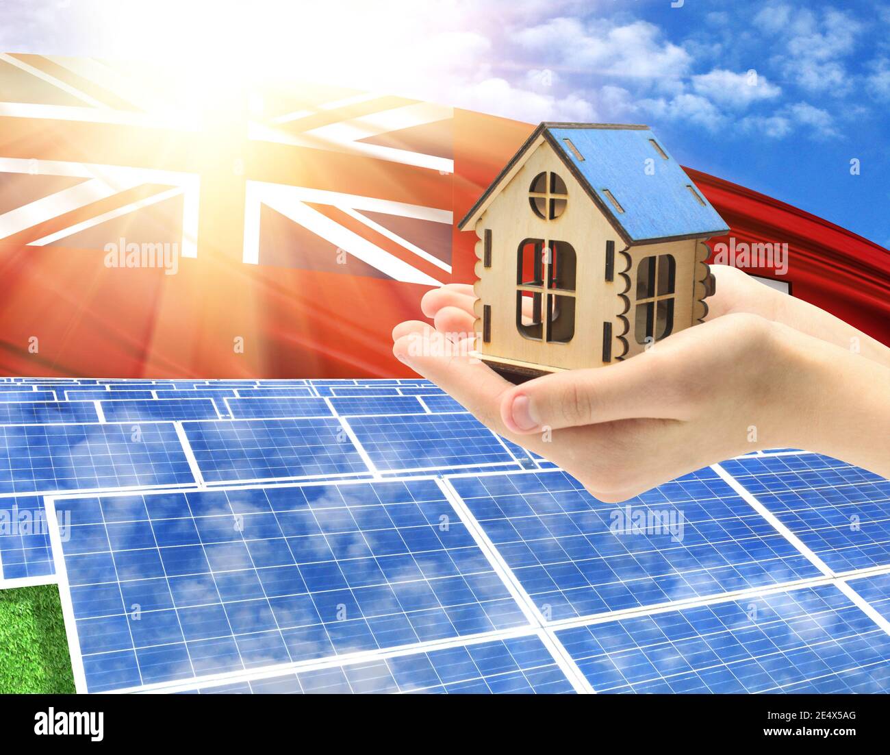 The photo with solar panels and a woman's palm holding a toy house ...