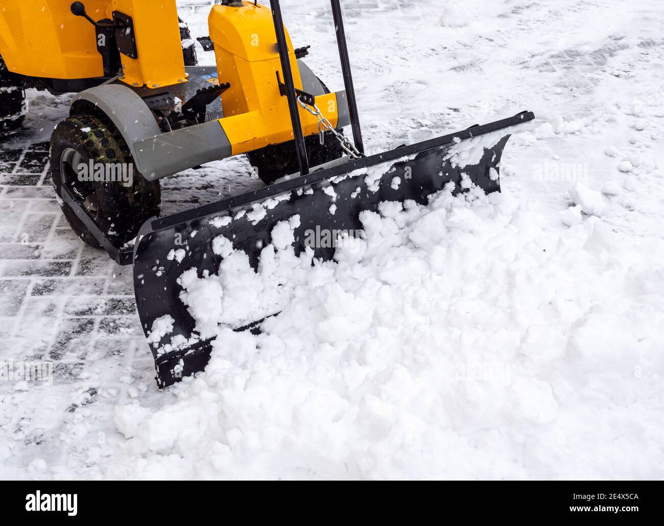 Pushing snow with a tractor on the footpath Stock Photo - Alamy