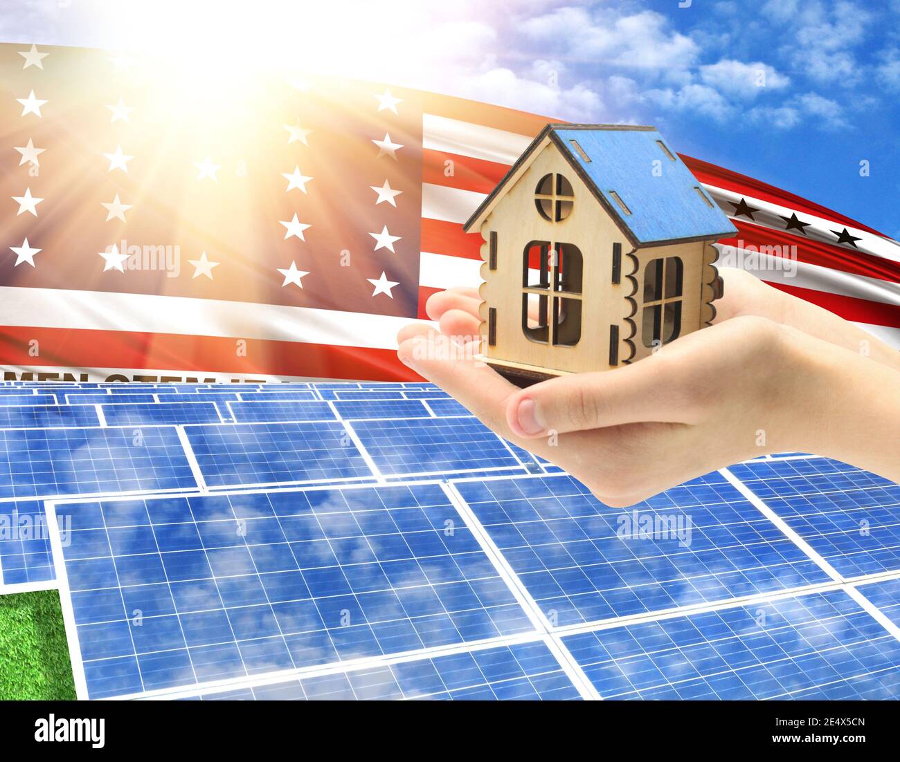 The photo with solar panels and a woman's palm holding a toy house ...