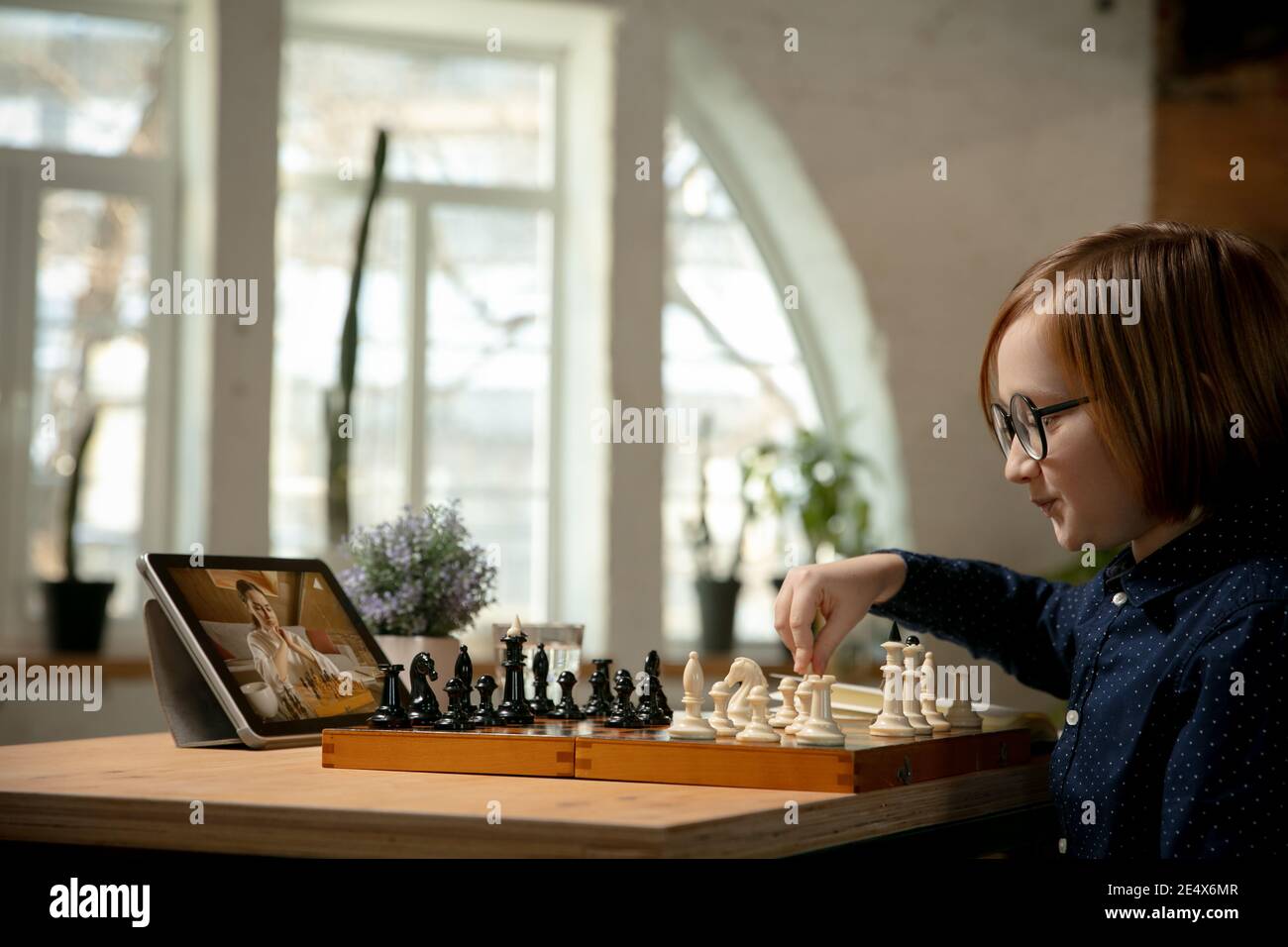 Smart little Caucasian boy chess player playing chess online using ...