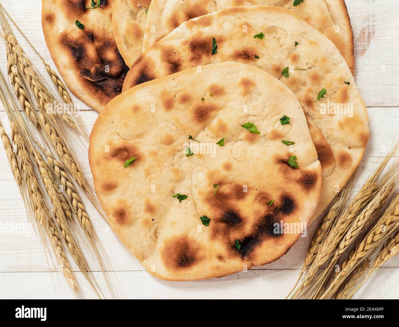 Fresh naan bread on white wooden background with copy space. Top view ...
