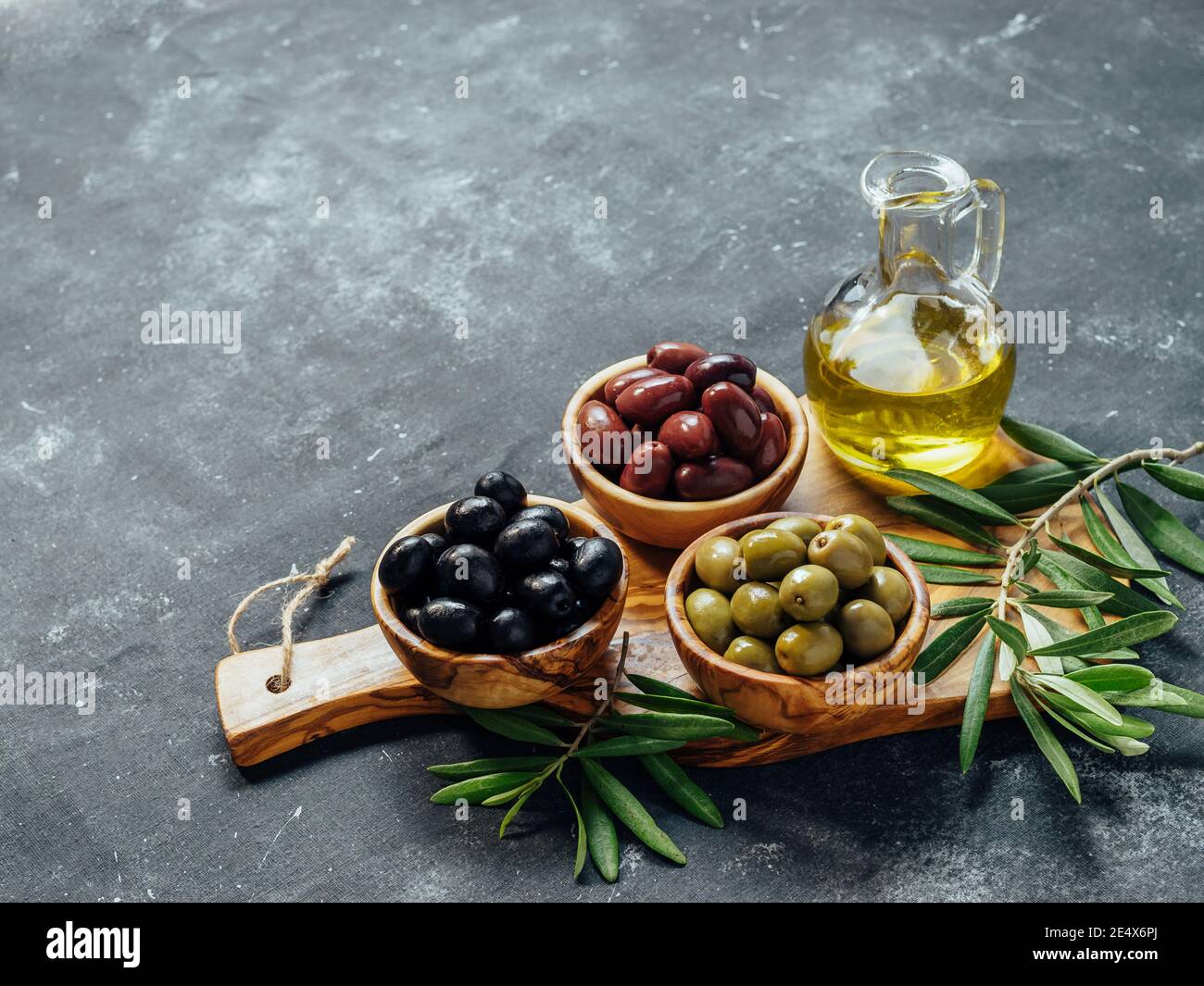 Set of green, black and red or pink olives and olive oil on gray ...