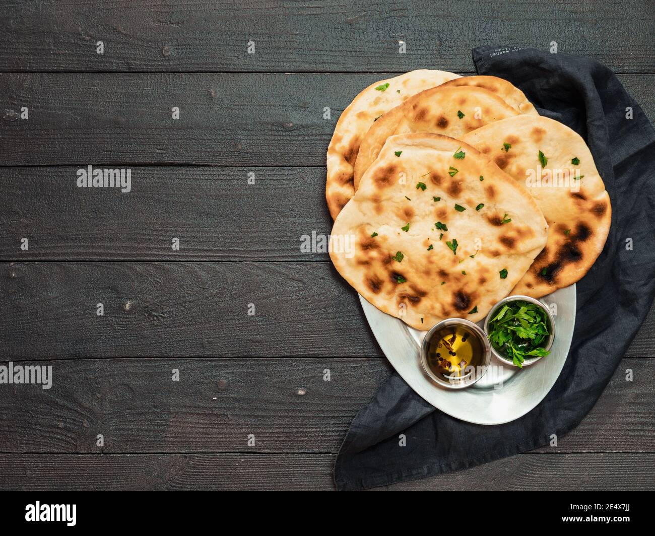 Fresh naan bread on dark wooden background with copy space. Several ...