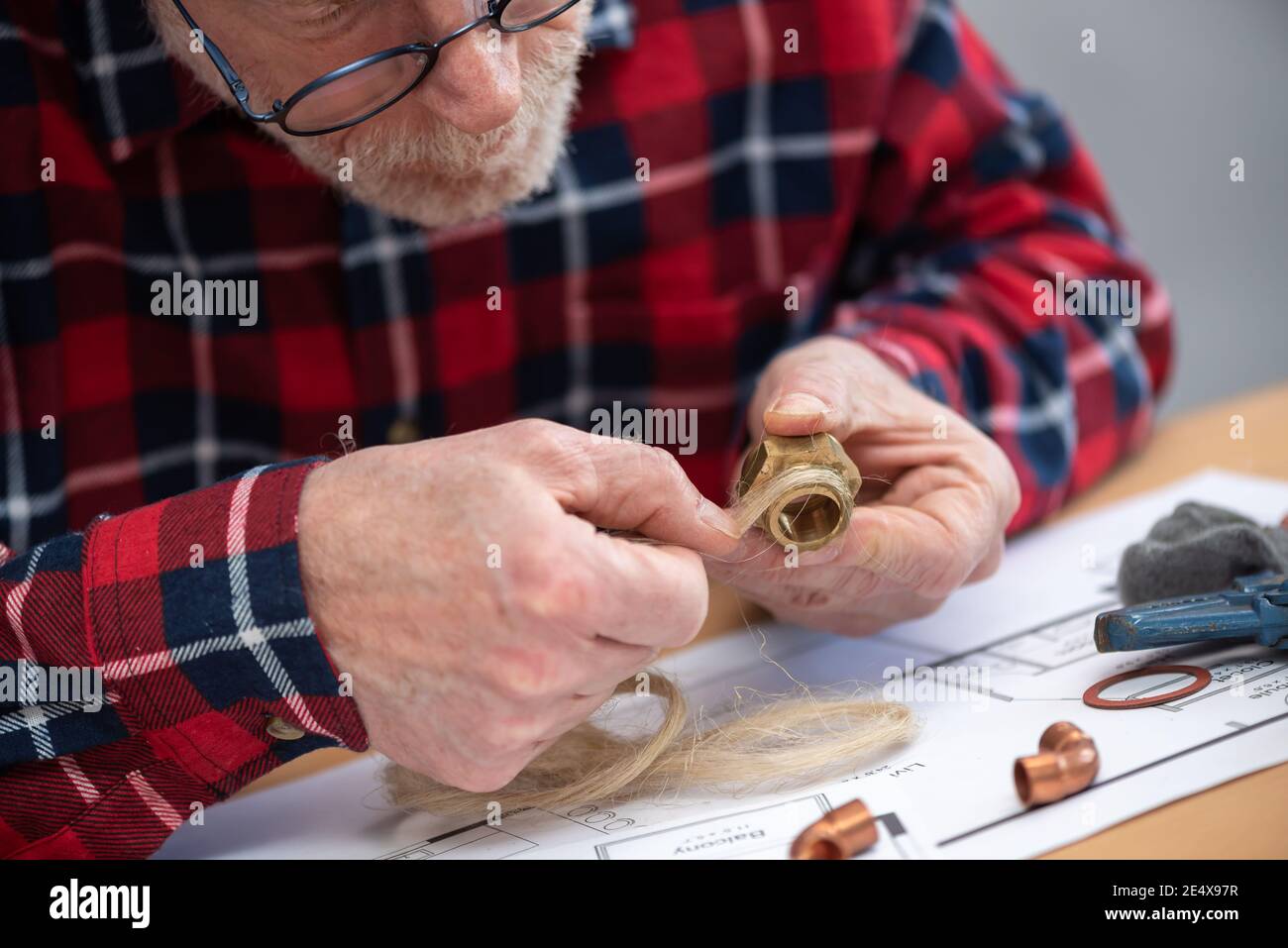 Plumber preparing fitting sealing with hemp fibers Stock Photo - Alamy