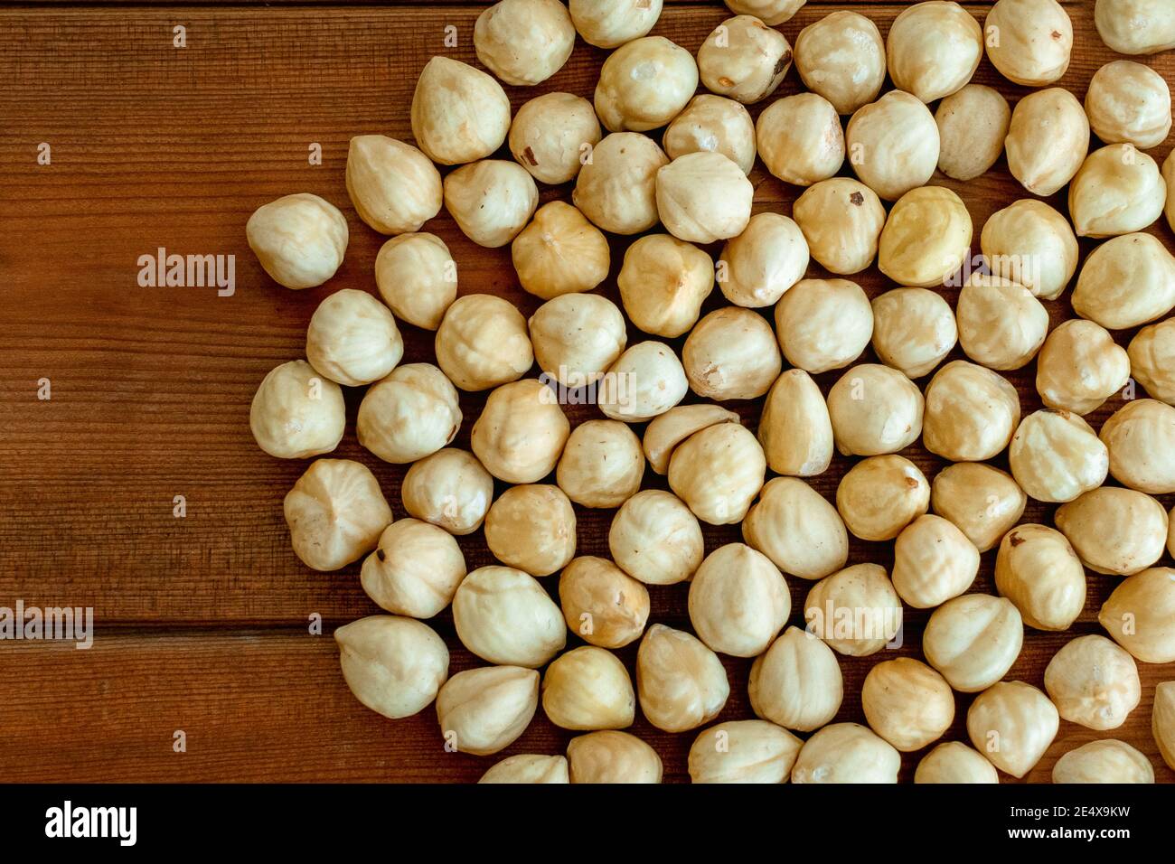 Scattered on the table roasted hazelnuts on a wooden table. Peeled ...