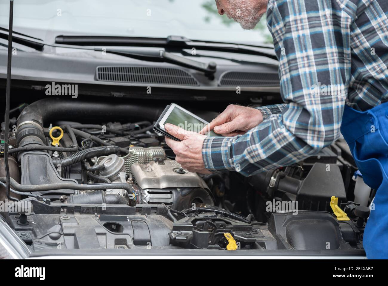 Car mechanic using digital tablet for checking car engine Stock Photo ...