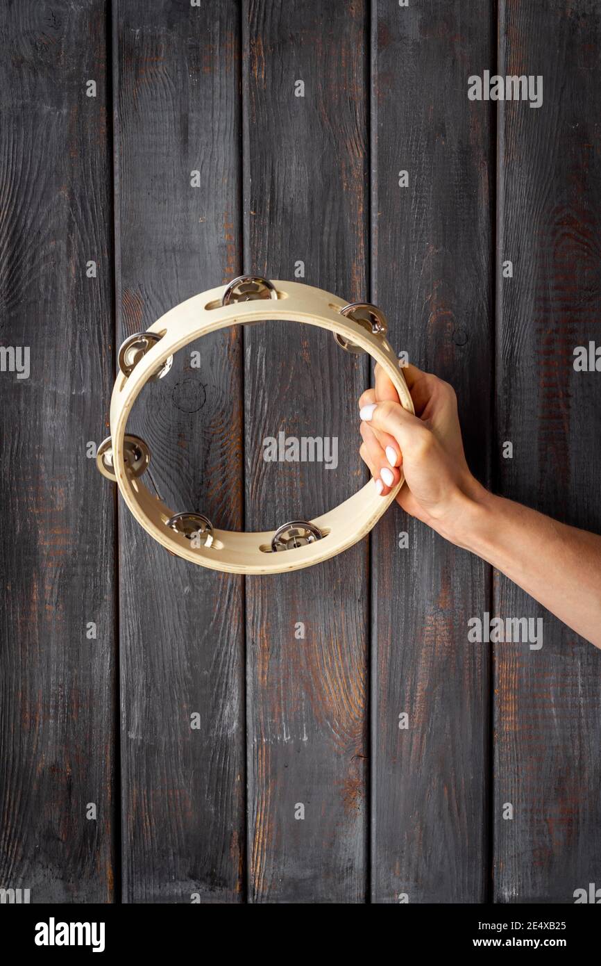 Wooden tambourine in hand. Percussion musical instrument, top view ...