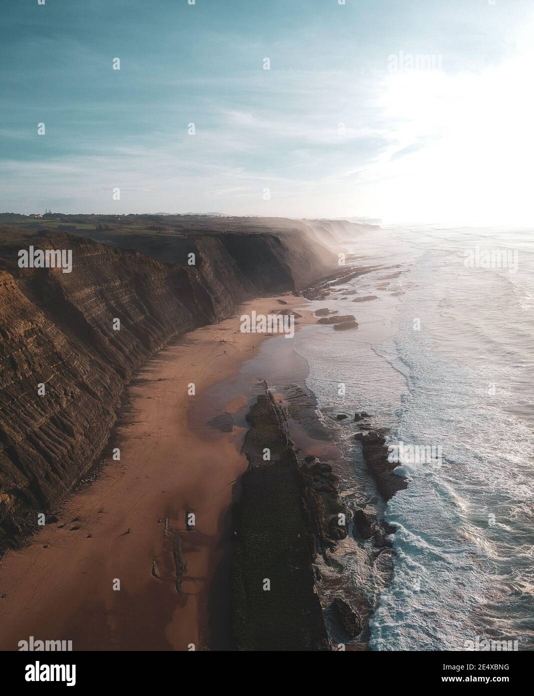 Aerial view of waves on a beautiful sandy ocean beach and cliff ...