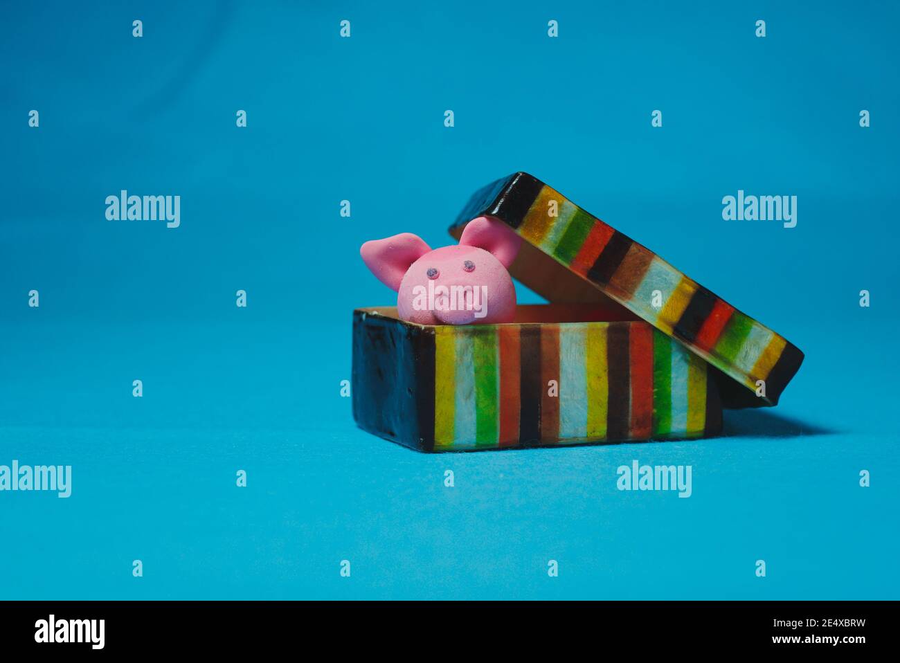 pink pig comes out of colored box Stock Photo - Alamy