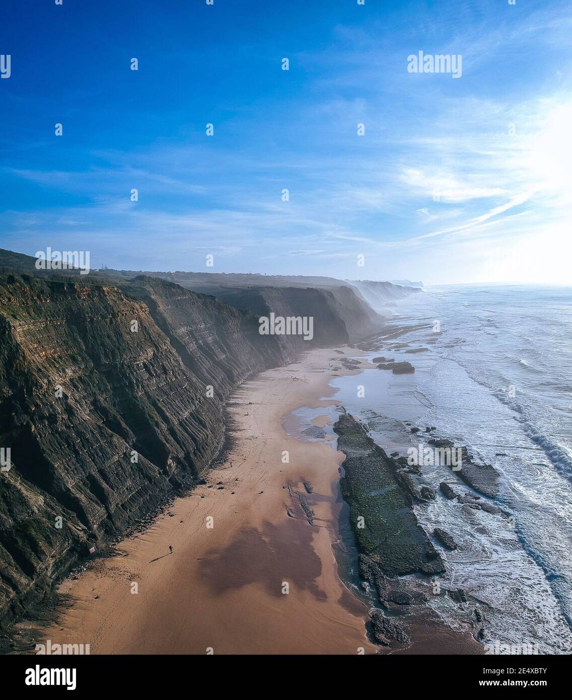 Aerial view of waves on a beautiful sandy ocean beach and cliff ...