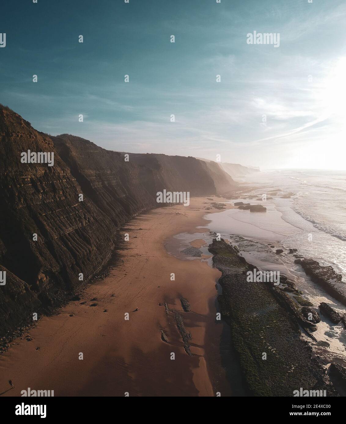 Aerial view of waves on a beautiful sandy ocean beach and cliff ...