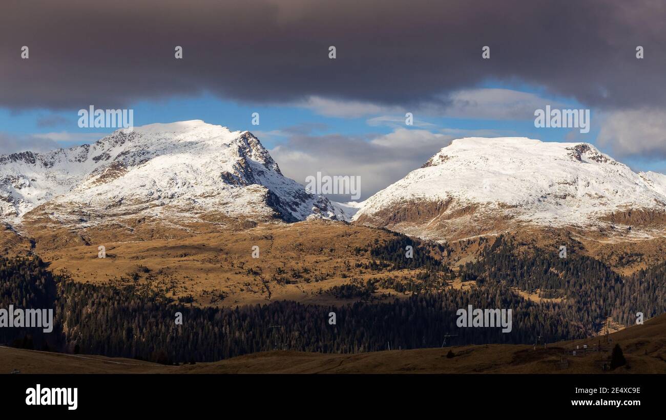 Landscape of the Dolomites covered in the snow under a blue cloudy sky ...