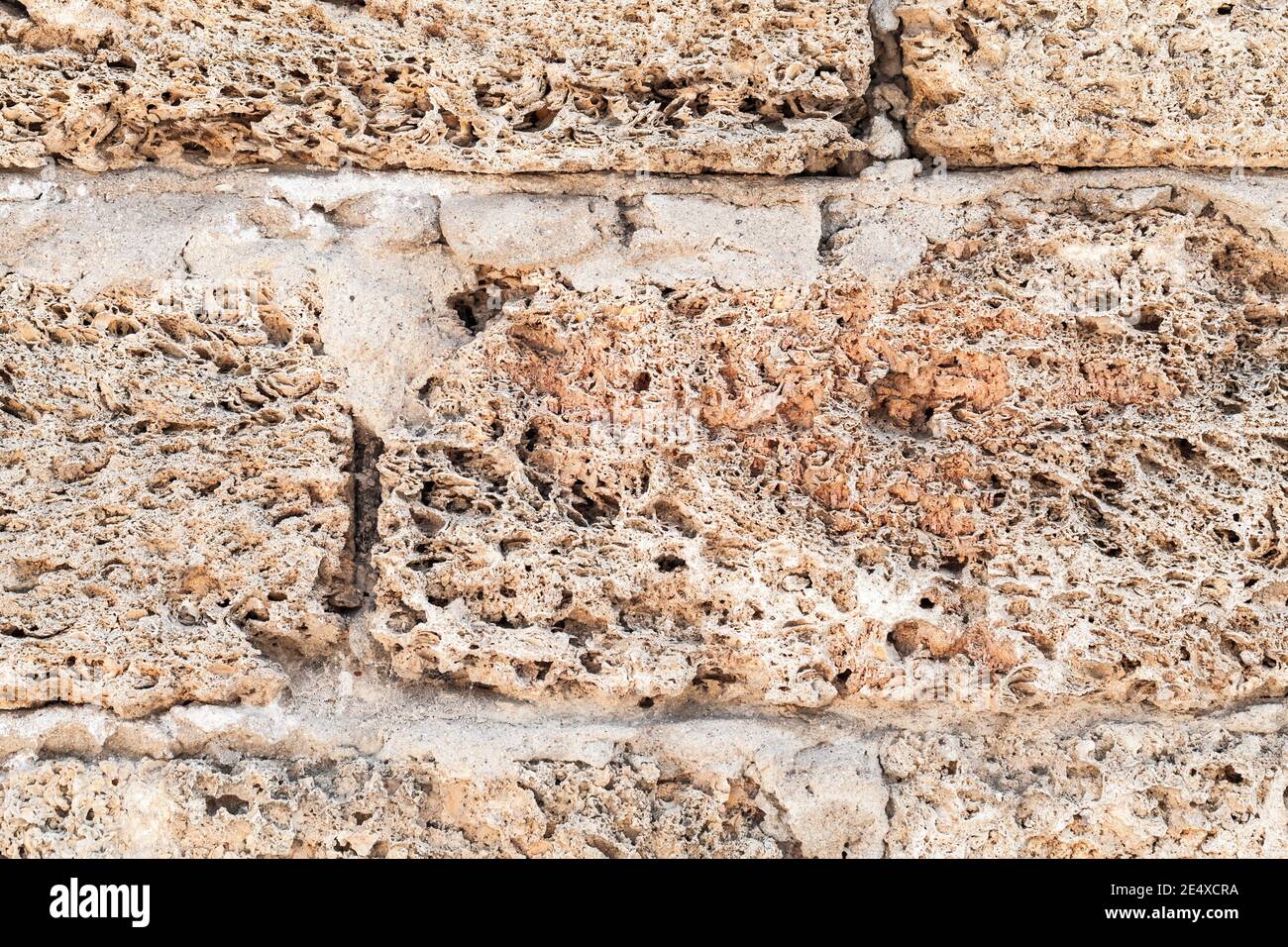 Grungy wall made of shell rock bricks, closeup background photo texture ...