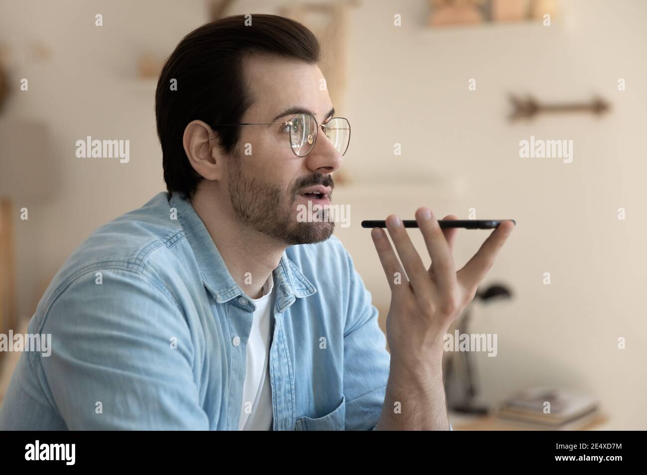 Confident young man communicating with friend by loud speaker Stock ...