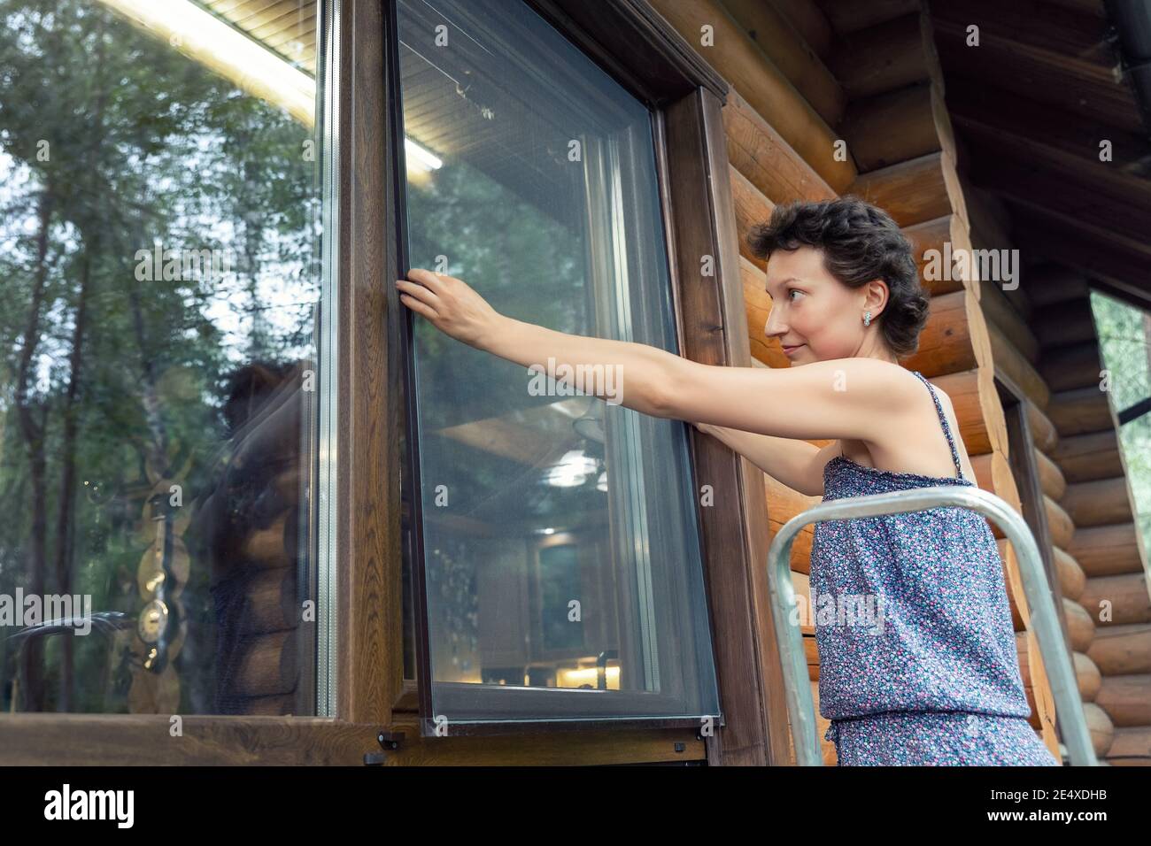 Young adult beautiful slim sporty caucasian woman stand on metal ladder ...