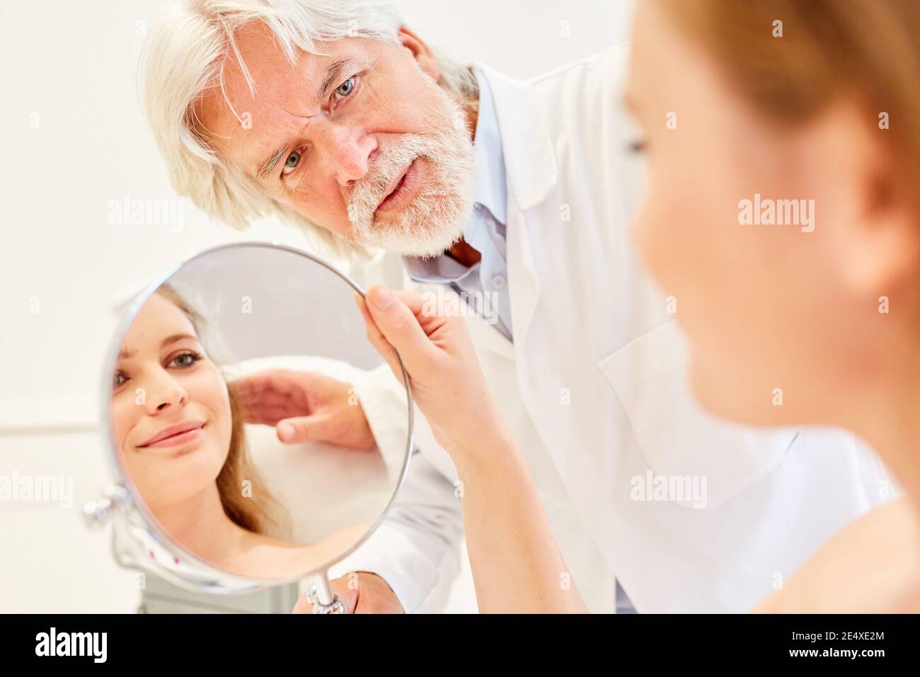 Patient looks in the mirror during a consultation with a plastic ...