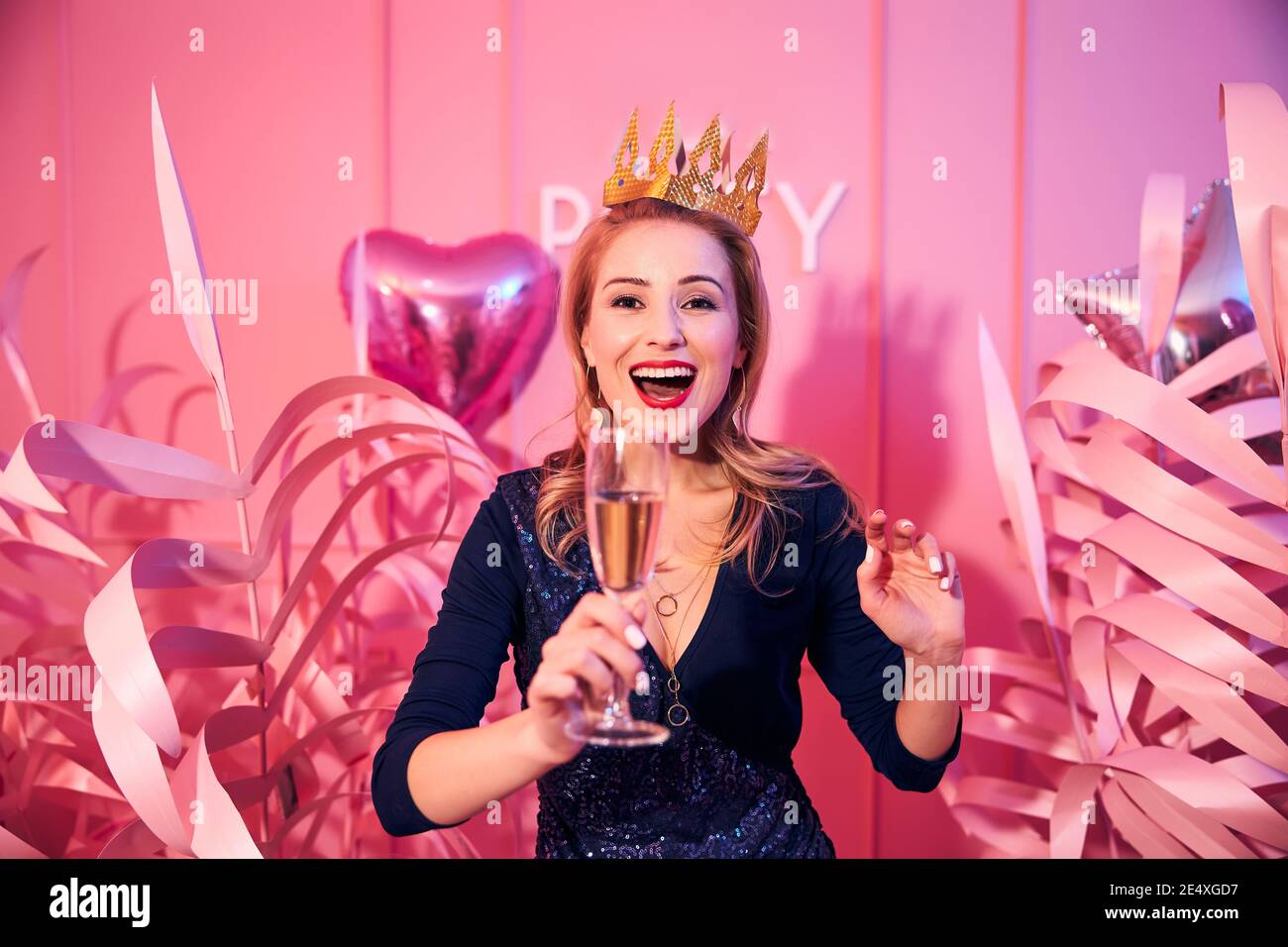 Glamorous merry lady holding a champagne flute Stock Photo - Alamy