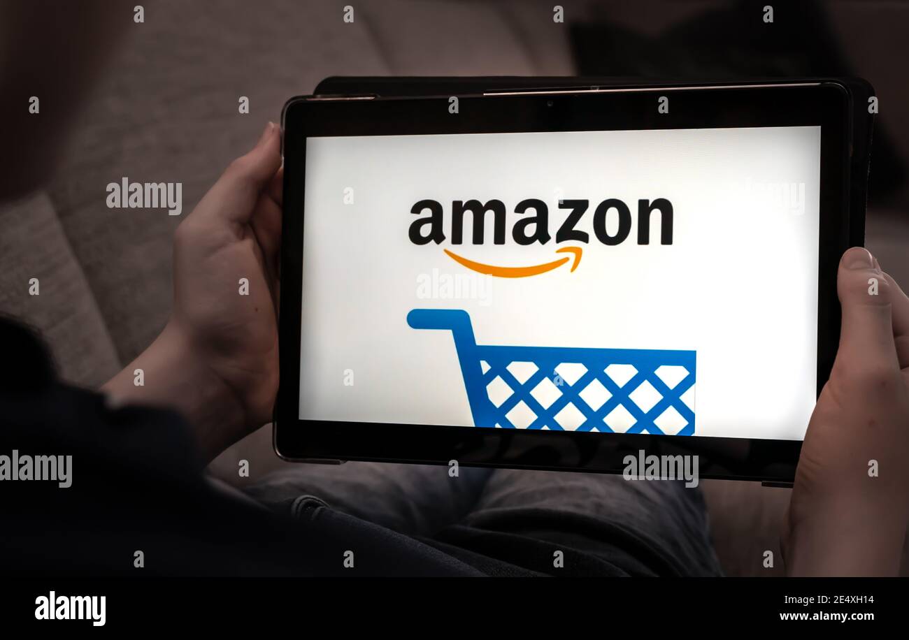 Hands holding tablet with Amazon shopping logo on a black screen Stock ...