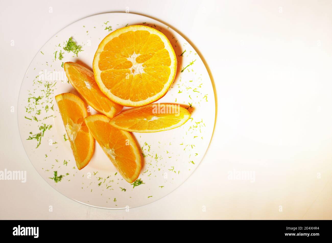 Top dish table of a plate with orange slices and half one on white ...