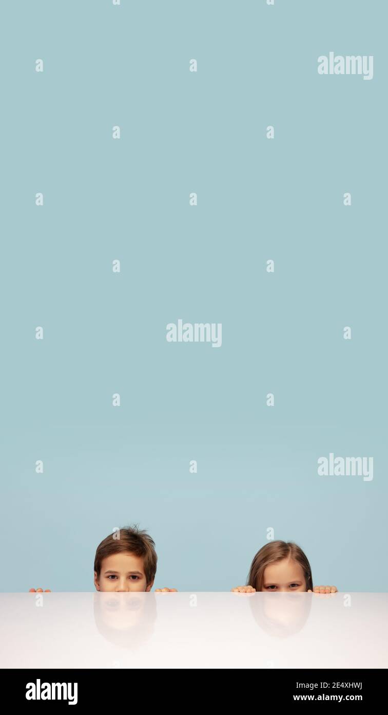 Looking up. Happy children isolated on blue studio background. Look ...