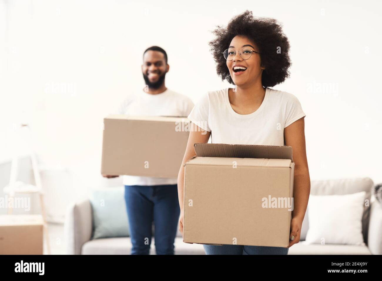 Excited African Couple Carrying Moving Boxes Entering Own Home Stock ...