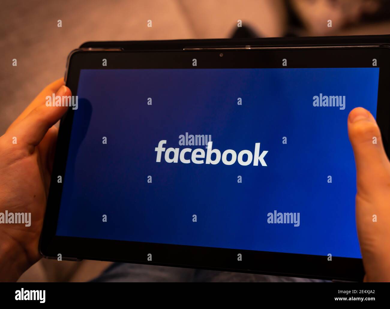 Hands holding tablet with Facebook logo on a black screen Stock Photo ...
