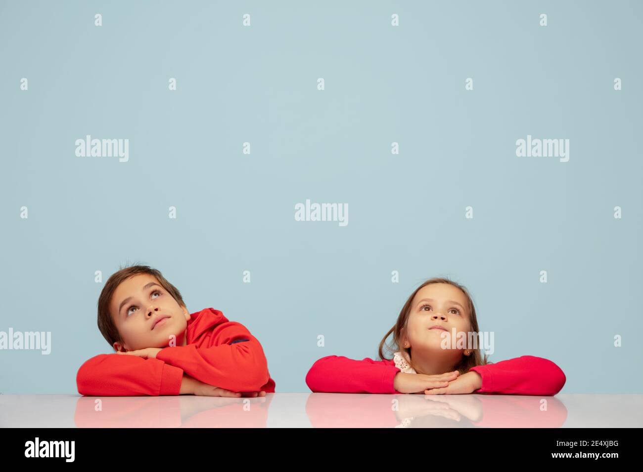 Looking up. Happy children isolated on blue studio background. Look ...