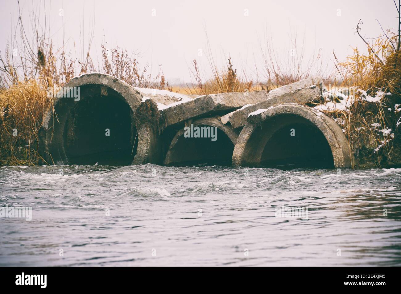 The water on the river flows from large pipes. Dam on the river Stock ...
