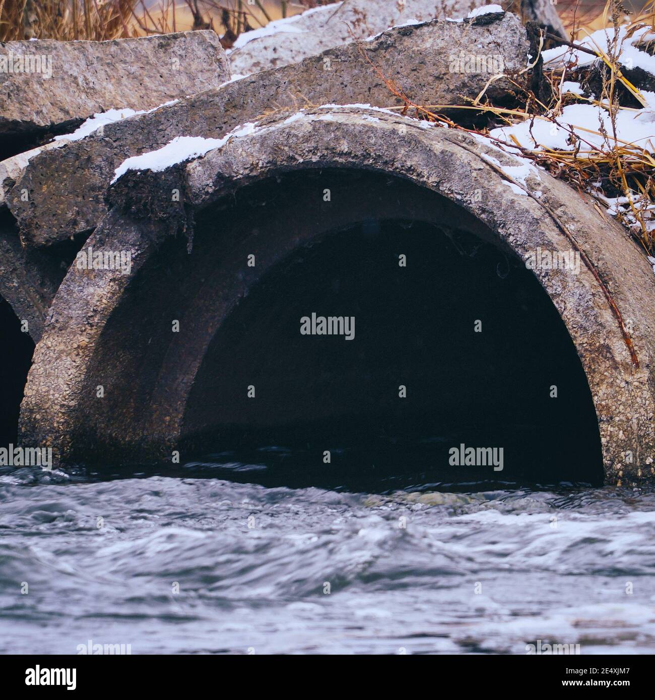 The water on the river flows from large pipes. Dam on the river Stock ...