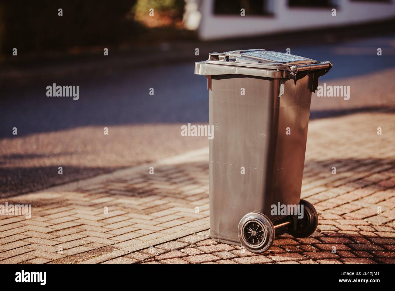 View of a garbage container on the street pavement Stock Photo - Alamy
