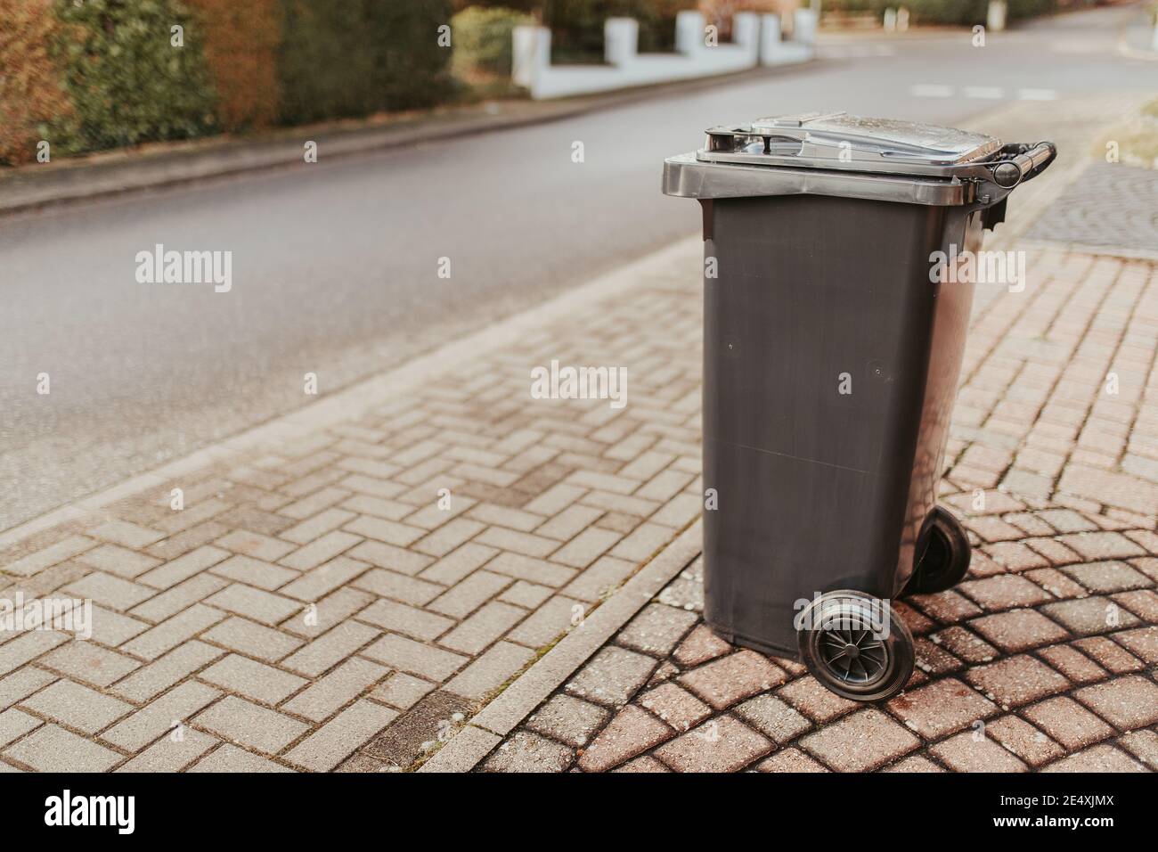 View of a garbage container on the street pavement Stock Photo - Alamy