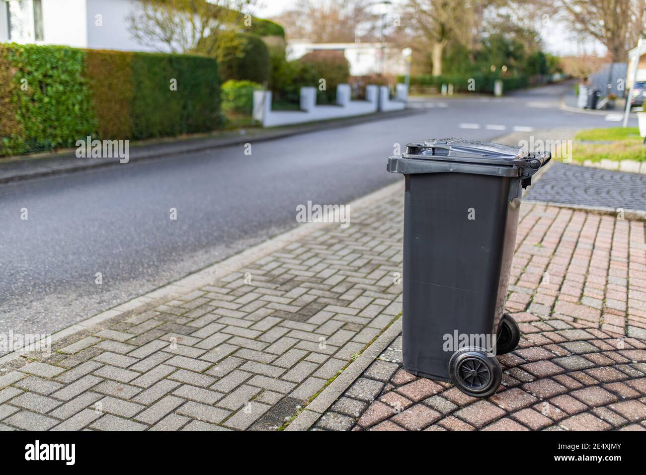 View of a garbage container on the street pavement Stock Photo - Alamy