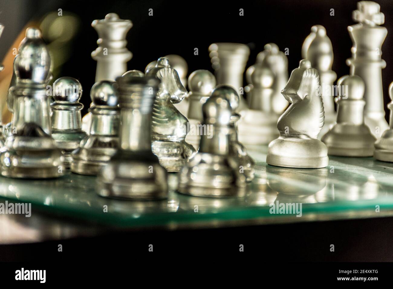 Glass chess pieces on board game Stock Photo - Alamy