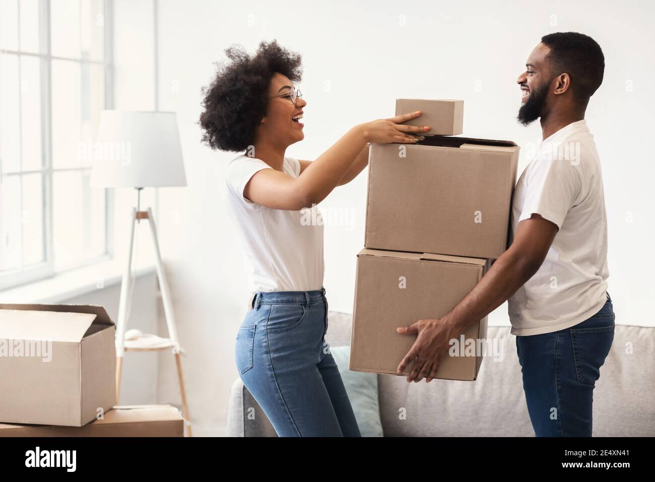 Happy African Couple Packing Moving Boxes Together Standing Indoors ...