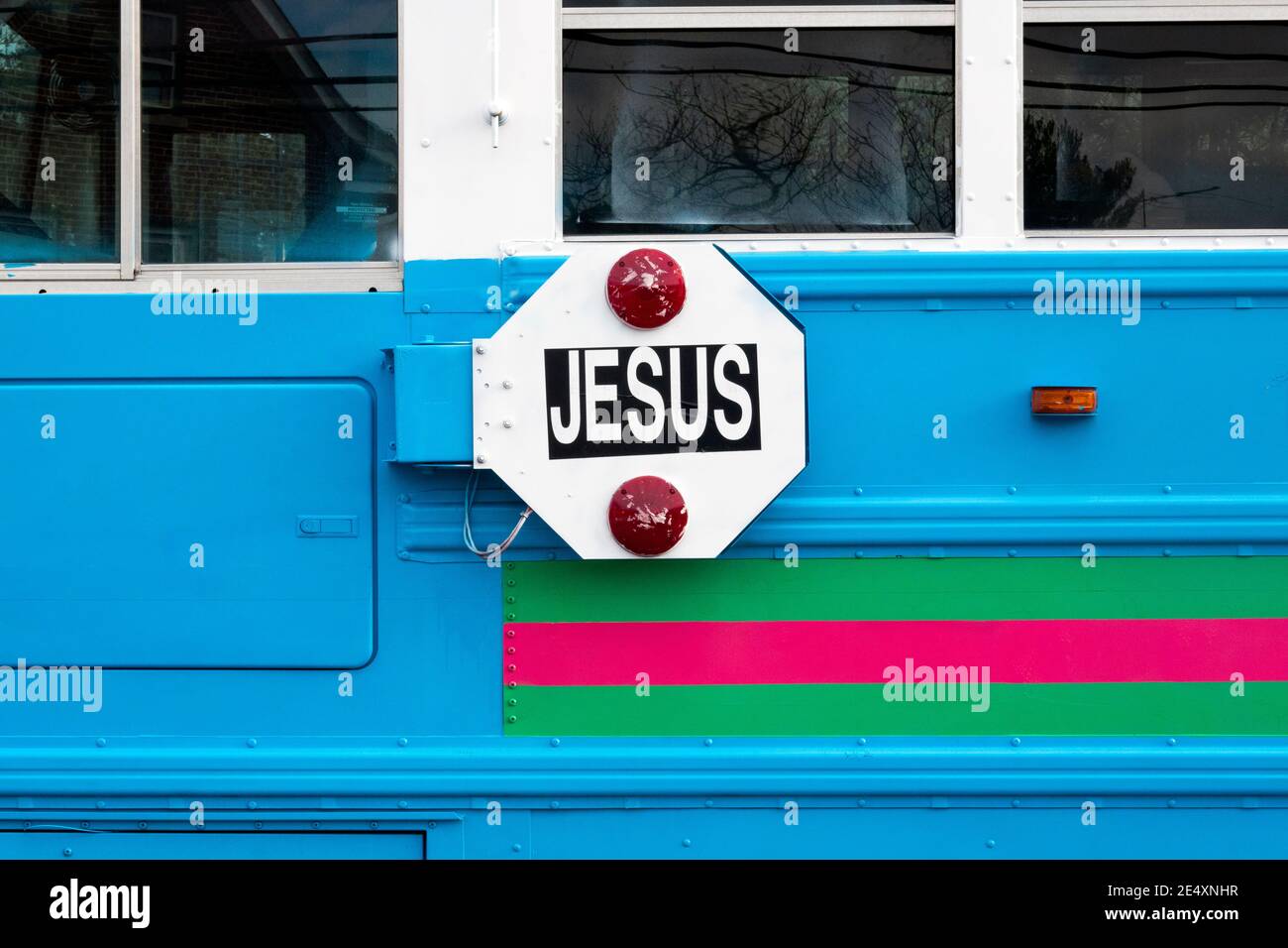 The name Jesus written on the back fo a very colorful bus 'stop' sign ...