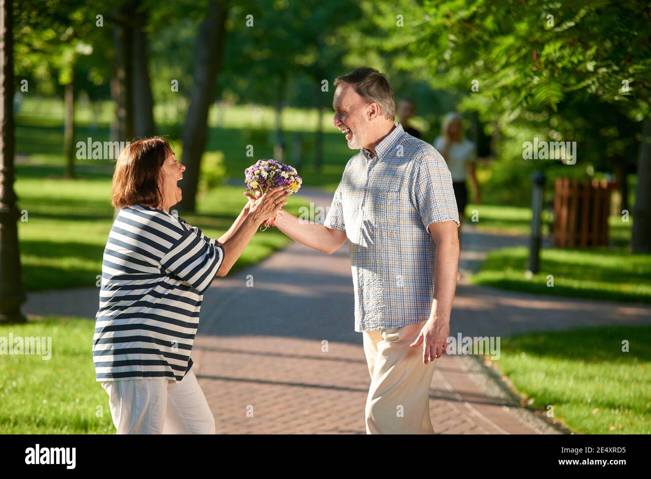 Happy woman recieving flowers from her husband Stock Photo - Alamy